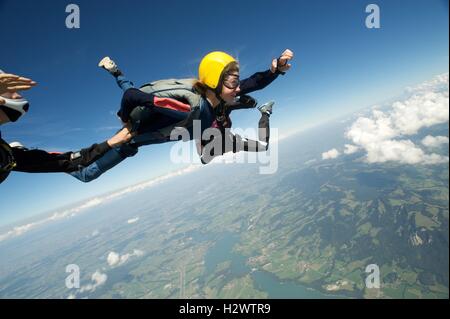 Woman on her first freefall jump with two instructors Stock Photo - Alamy