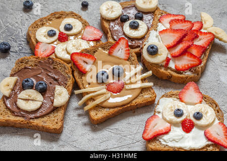 Funny animal faces toasts with spreads, butters, banana, strawberry and ...