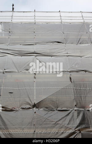 Building covered in scaffolding & plastic sheets Stock Photo - Alamy