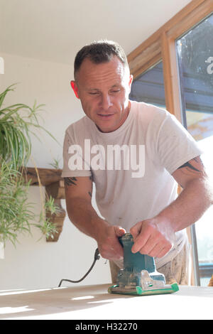 Carpenter Using Electric Sander. Carpenter sanding a wood with sander ...