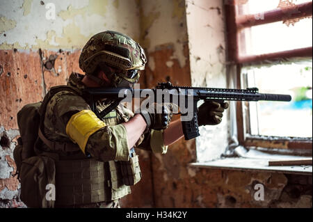 Military man sniper with automatic rifle aims into the distance - view ...