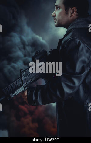 Man with long leather jacket and assault rifle, black smoke background ...