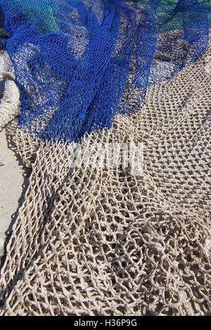 Close-up of beige fishing nets with visible knots and patterns ...