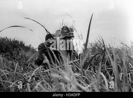 On the Eastern front German infantryman is digging a hole in the ground ...