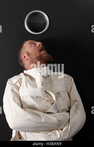 Insane man in strait-jacket screaming in isolation Stock Photo - Alamy