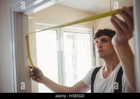 Carpenter measuring a door frame Stock Photo - Alamy
