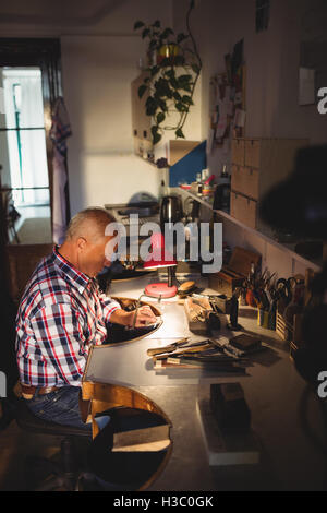 Goldsmith working and creating jewelry Stock Photo - Alamy