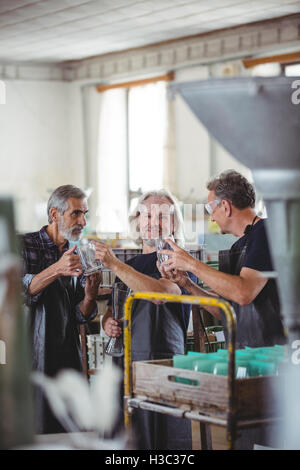 Glassblowers examining glass vase in glassblowing factory Stock Photo ...