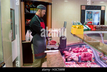 Butcher checking the weight of meat at counter Stock Photo - Alamy