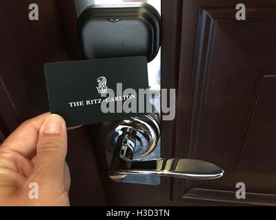 Hotel room keycard door lock with a hand inserting a magnetic stripe ...