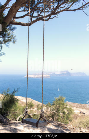 Swing over the precipice on the sea background Stock Photo - Alamy
