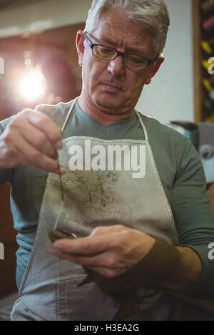 Shoemaker stitching shoe sole with needle Stock Photo - Alamy