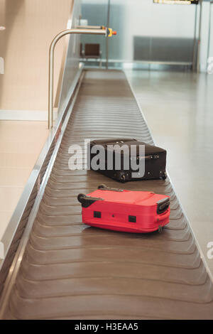 Black suitcase arriving on baggage carousel inside modern airport ...