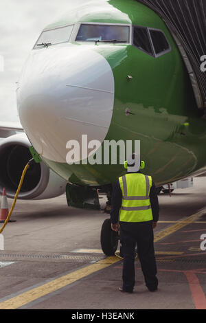 Rear view of a ground crew directing an airplane Stock Photo - Alamy