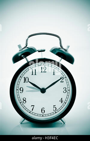 an alarm clock adjusting backward one hour and the text end of daylight ...