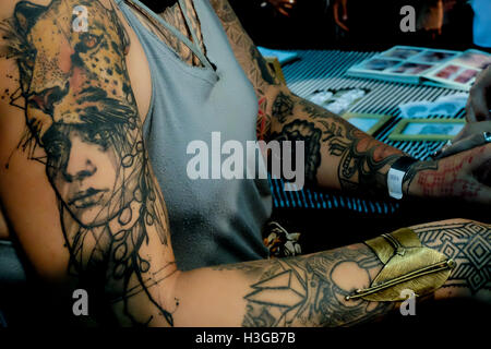 Tel Aviv, Israel. 7th October, 2016. A tattoo artist tattoos a woman's ...