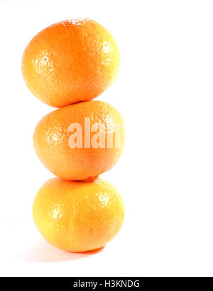 Vertically piled up three ripe oranges isolated on white background ...