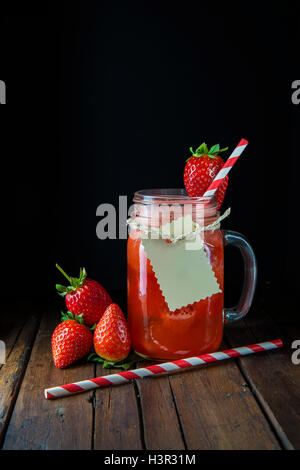 Glass of milk with stripped red paper straw and jug of milk on white ...