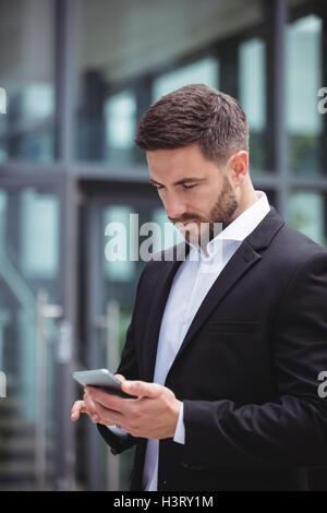 Young businessman talking on mobile phone while working on laptop in ...