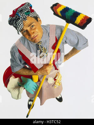 Young man in apron cleaning shelf with pp-duster at home Stock Photo ...