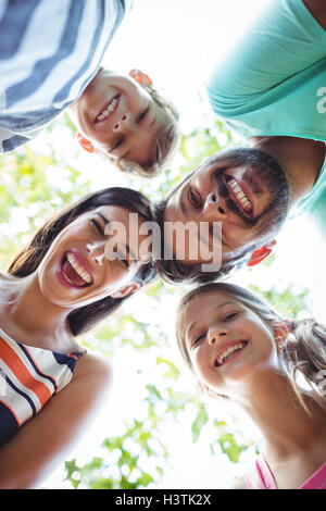 Cheerful family forming huddle against sky Stock Photo - Alamy