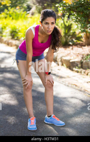 Sporty woman tired and exhausted breathing and cooling down after ...