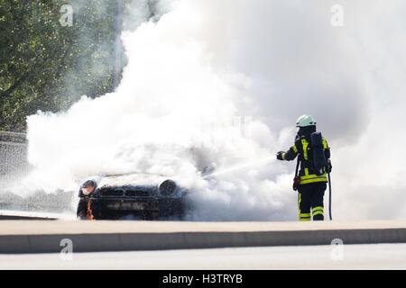 Firefighter extinguishes a burning car Stock Photo - Alamy