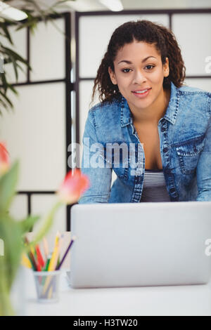 Portrait of young businesswoman using laptop computer isolated on gray ...