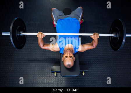 A man doing a bench press with a barbell in the gym Stock Photo - Alamy