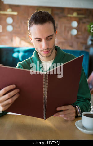 Man looking at drink menu in the Touzan Bar at Hyatt Regency Kyoto ...