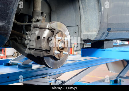 A car ready for fix on a workshop bridge, brakes are visible Stock ...