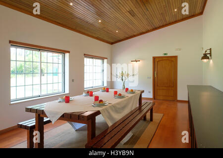 A wooden dining table set with empty plates indoor. Restaurant interior ...