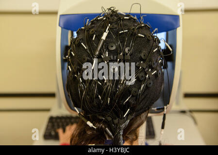 Person undergoing an electroencephalogram with an EEG cap to scan her ...