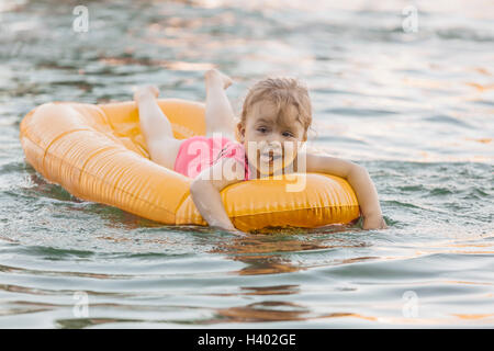 Girl lying on raft Stock Photo - Alamy