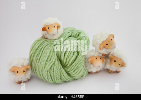 Cute sheep playing together with a ball of green wool Stock Photo - Alamy