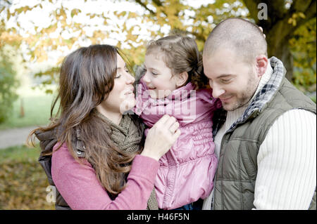 Happy parents with daughter in autumn park, family portrait amid fall ...