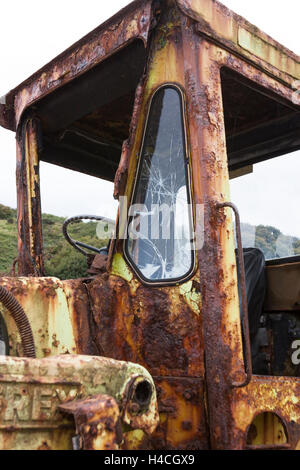 Old rusty excavator with broken window on sandy ground Stock Photo - Alamy