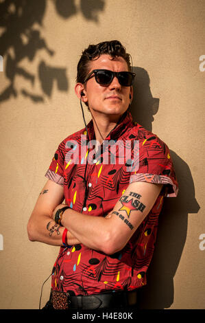 Model wearing in-ear buds, or headphones, to listen to their music ...