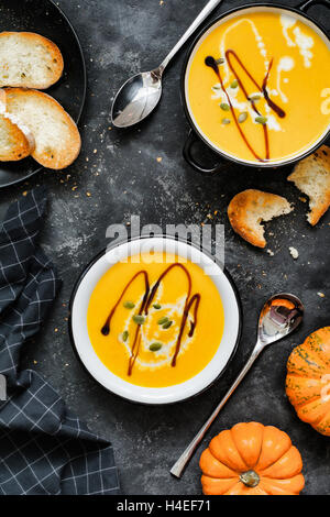 Pumpkin cream soup garnished with heavy cream and rosemary. Thick ...
