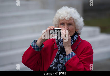 An elderly pensioner oap using technology mobile phone to take a ...