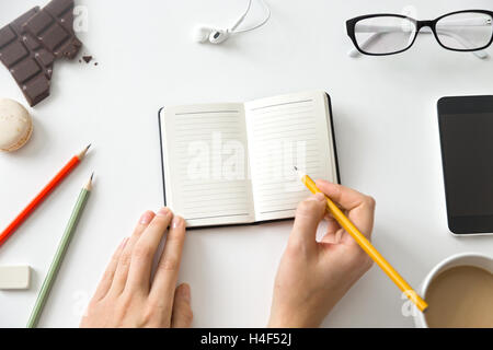 Top view of female hands holding calendar on black background. The ...