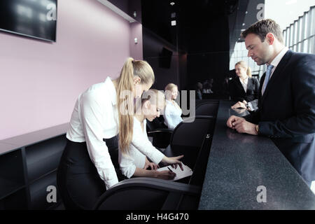 Business people filling forms at front desk Stock Photo - Alamy