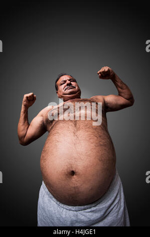 The strong and fat man showing his muscles and belly Stock Photo ...