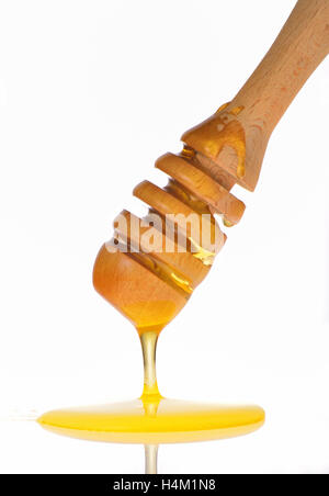 Wooden honey dipper with honey on white background. Close-up Stock ...