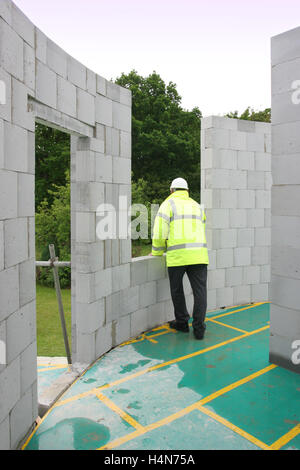 A builder inspects concrete blocks used to build a circular turret room ...