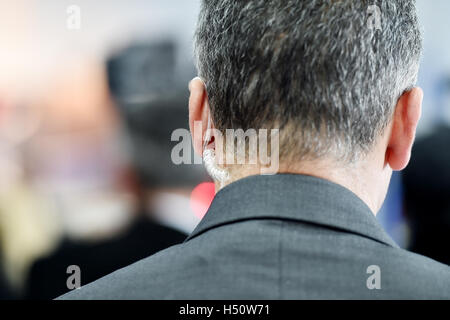 Detail with a bodyguard wearing in ear headset Stock Photo - Alamy