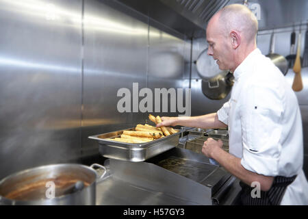 Chef deep frying food in a commercial kitchen in the UK Stock Photo - Alamy