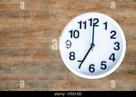 Wall clock show seven o'clock on white marble texture. Office clock ...