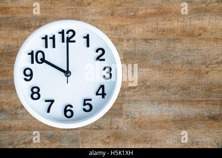 Wall clock show ten o'clock on white marble texture. Office clock show ...