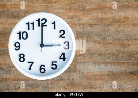 Wall clock show three o'clock on white marble texture. Office clock ...